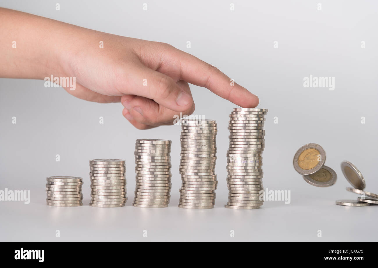 Finger pushing a pile of coins, column of coins falls , business crisis ...
