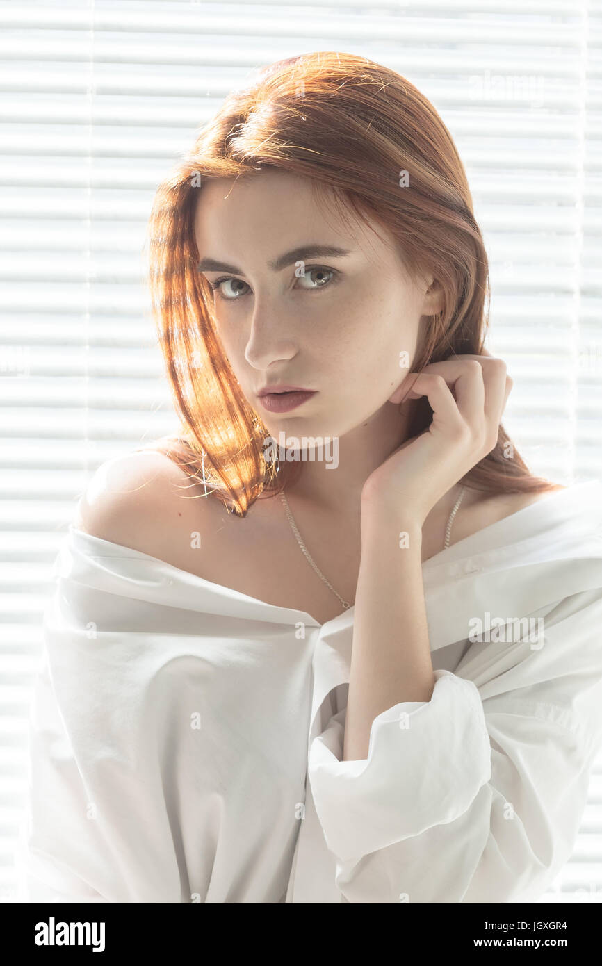 sensual beautiful woman sitting at window with blinds in sunlight Stock Photo - Alamy