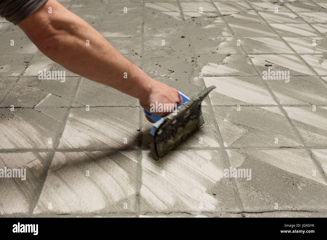 Masterfully gluing ceramic tiles in an industrial room Stock Photo - Alamy