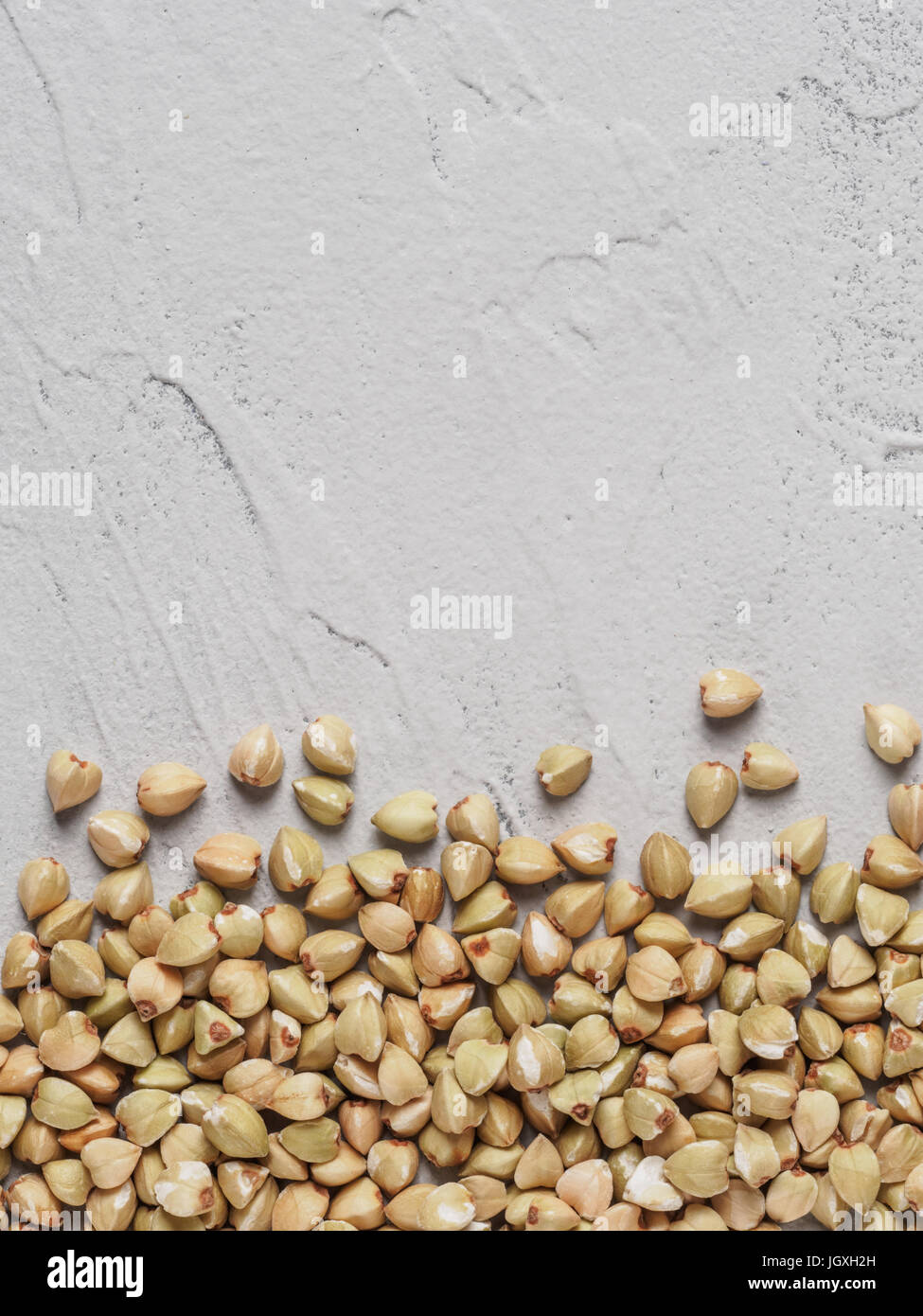 Raw green buckwheat on gray concrete background Healthy food and diet ...