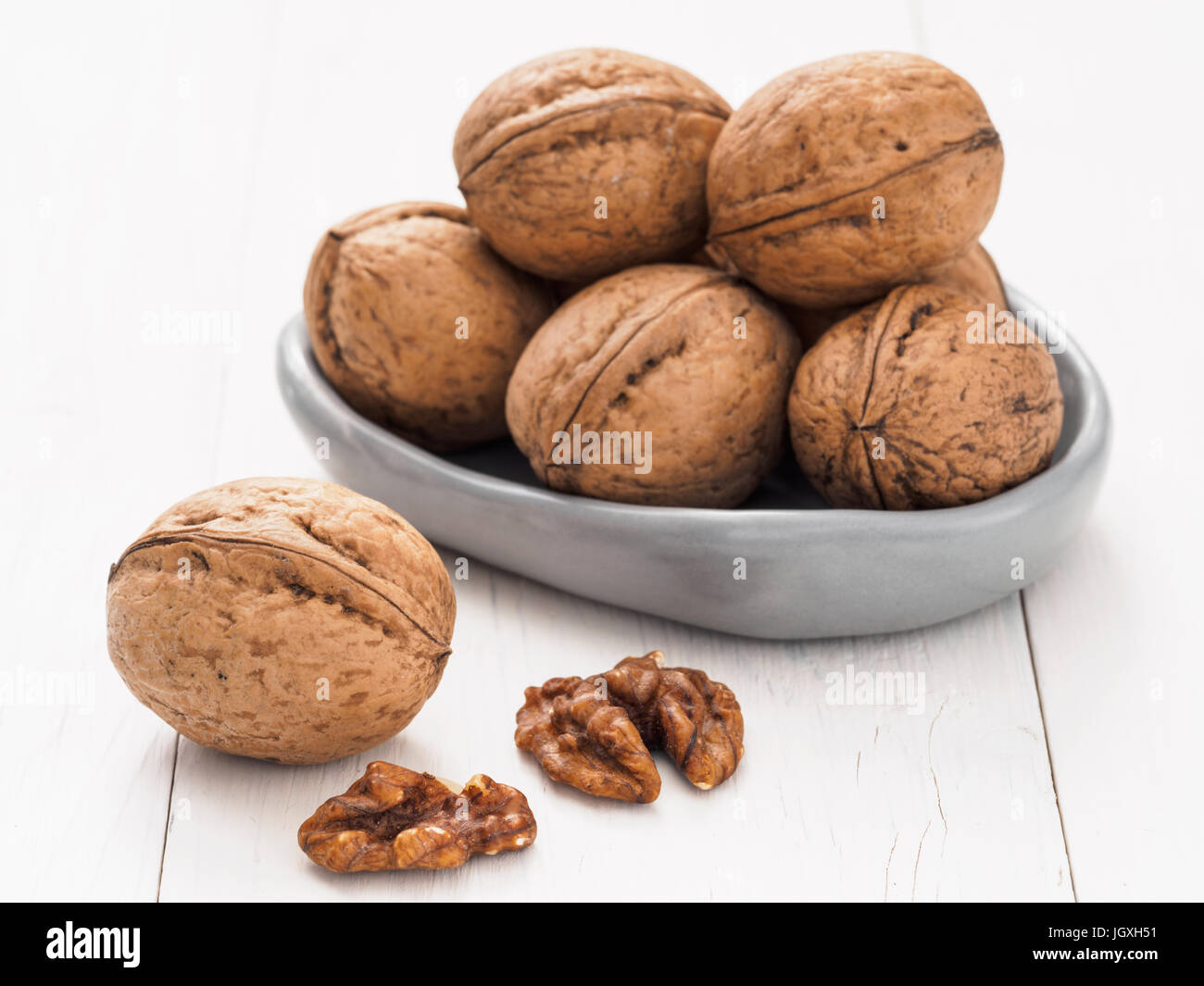 Close up view on inshell walnut on white wooden background Stock Photo ...