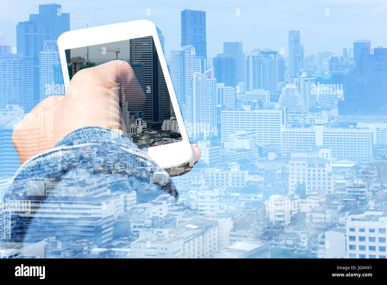 Double exposure image of using smart phone with cityscape background ...