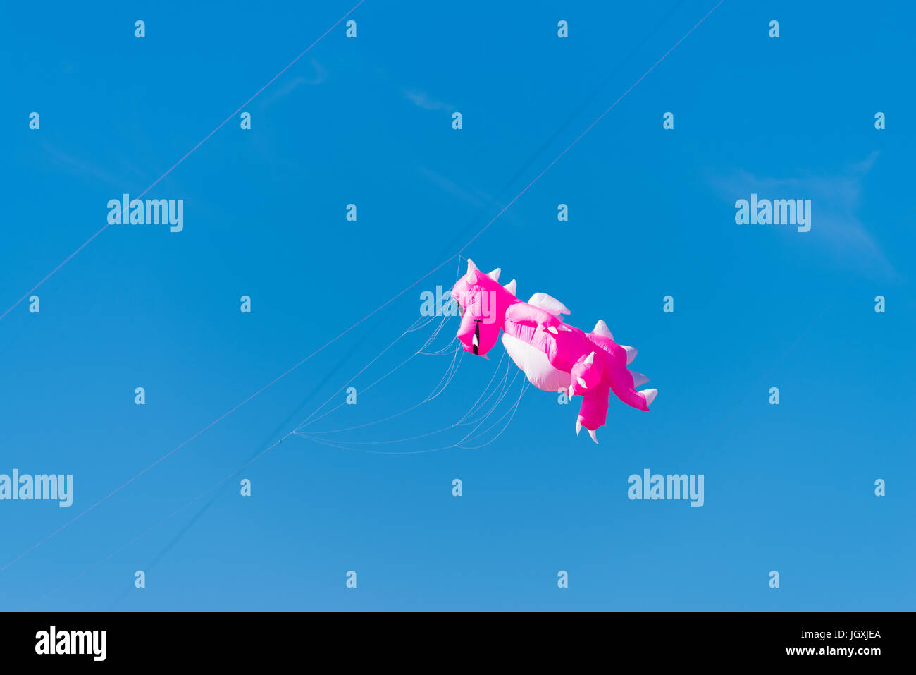pink dragon shaped kite against a blue sky Stock Photo - Alamy