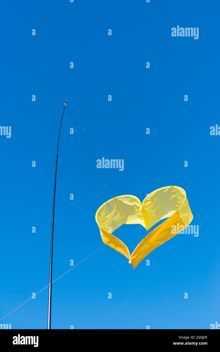 yellow heart shaped kite against a blue sky Stock Photo - Alamy