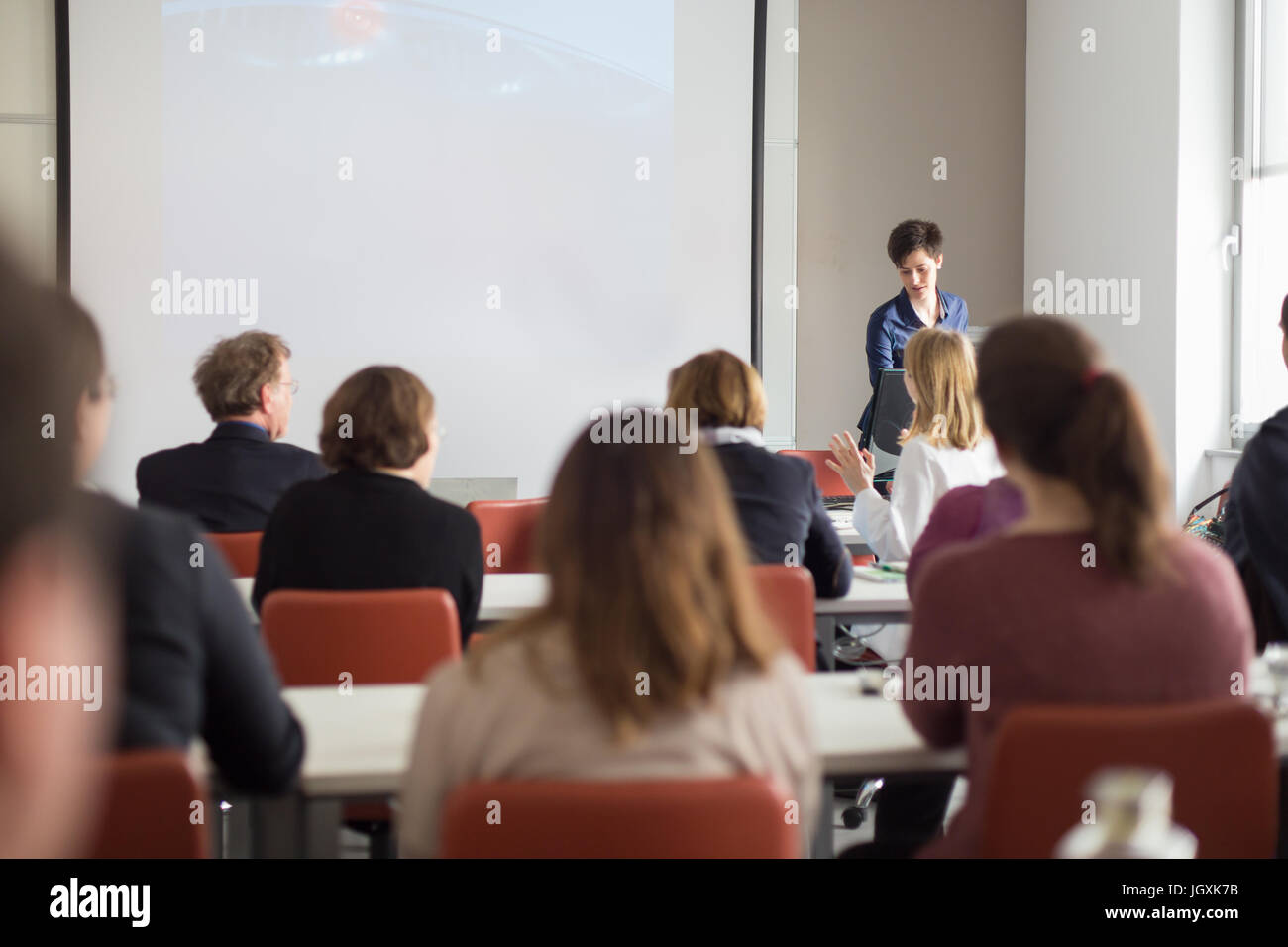 Woman giving presentation in lecture hall at university Stock Photo - Alamy