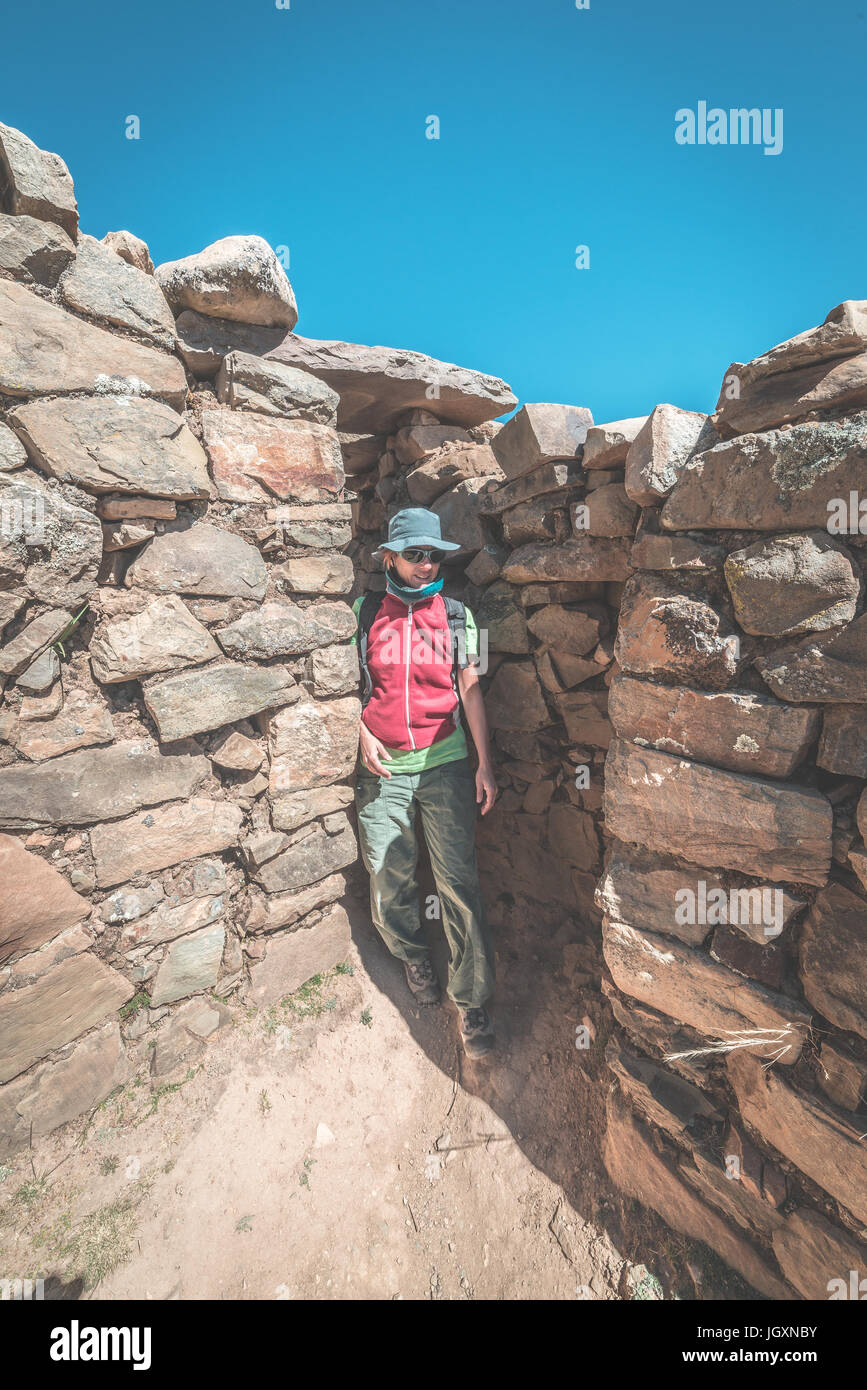 Tourist exploring the ancient mysterious Inca labyrinth-like settlement ...