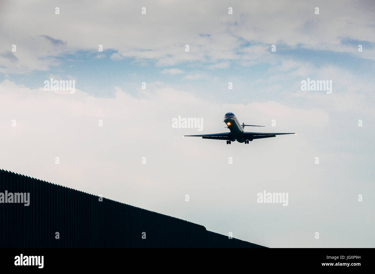 Airplane approaching runway to land at airport Stock Photo - Alamy