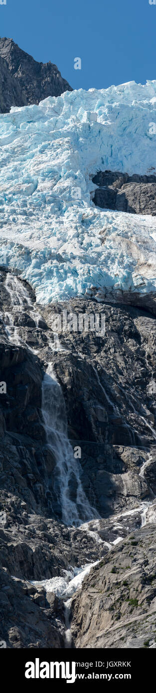 Water from a melting glacier cascades down the face of the mountain ...