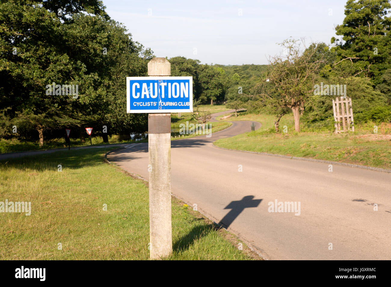Caution sign post warning cured long downhill in Richmond Park Stock ...