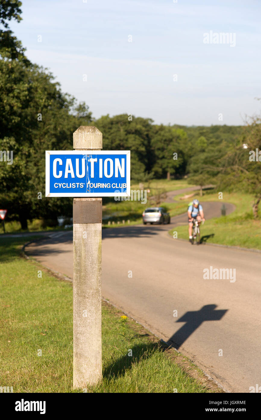 Caution sign post warning cured long downhill in Richmond Park Stock ...