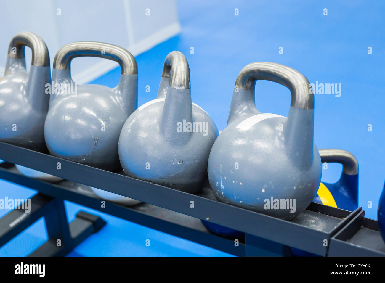 Blue kettlebells in a row in a gym - focus on the front kettlebell ...