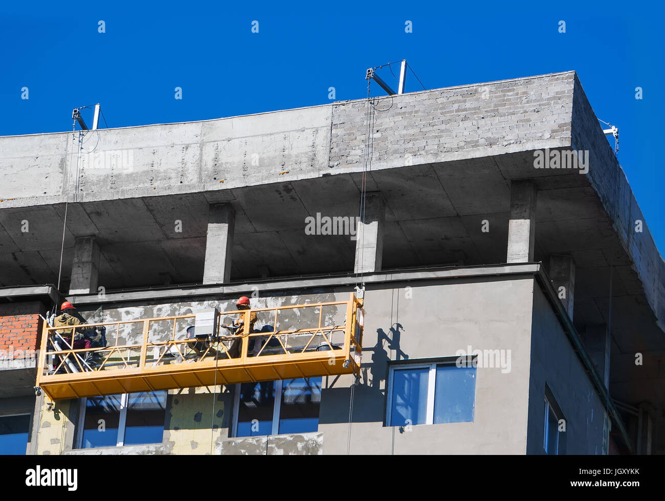 Working on the lift at a height of daubed plaster building Stock Photo ...