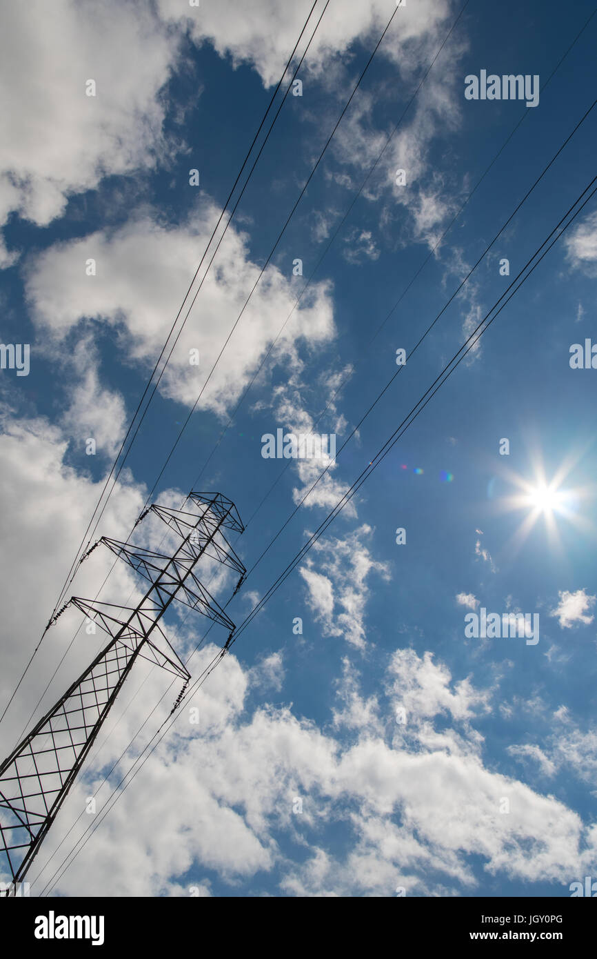 power tower with sun shining behind the clouds Stock Photo - Alamy