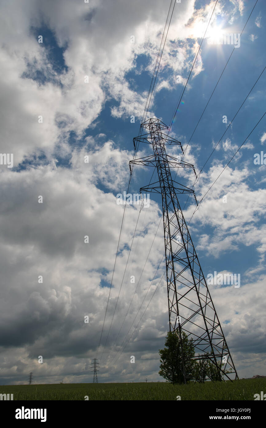 power tower with sun shining behind the clouds Stock Photo - Alamy