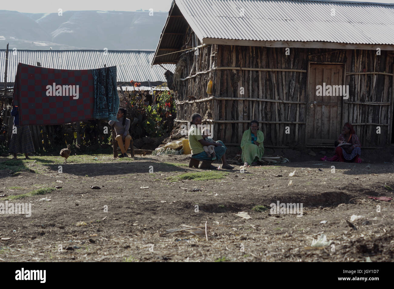 poor wooden houses with people in front of them Stock Photo - Alamy