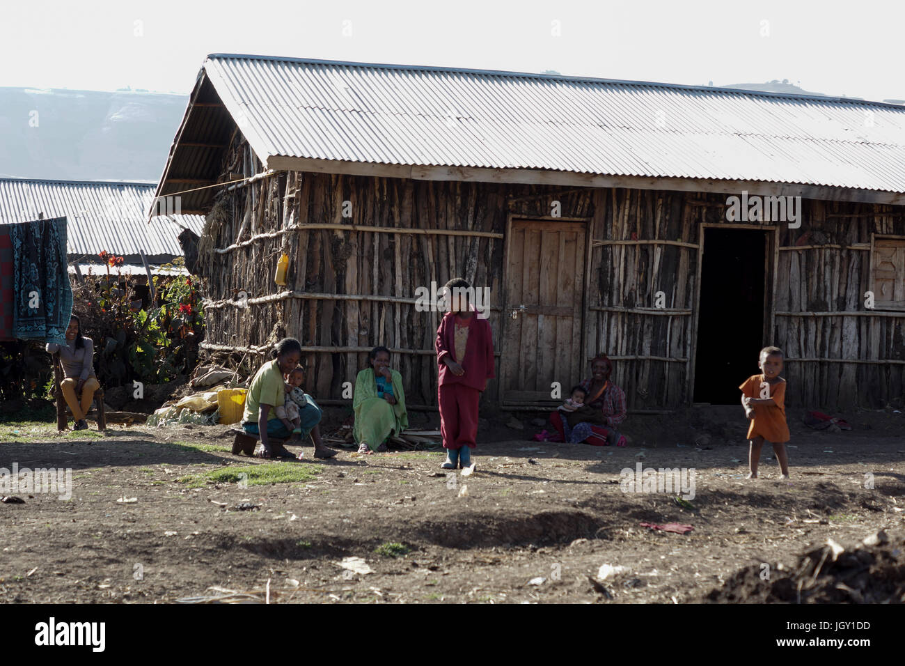 poor wooden houses with people in front of them Stock Photo - Alamy