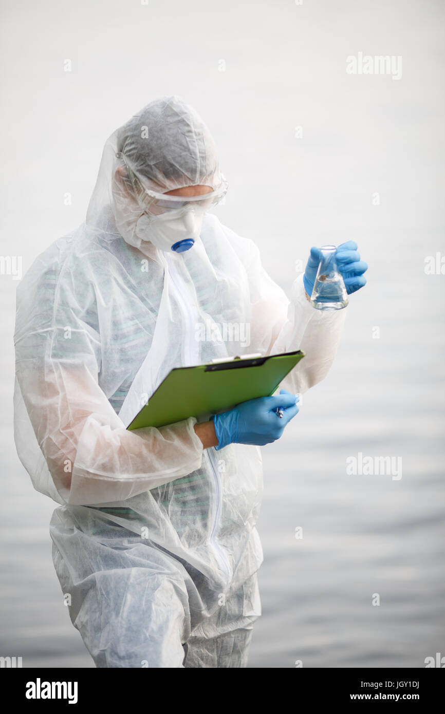 Ecologist with bulb and folder on river bank, blurred background Stock ...