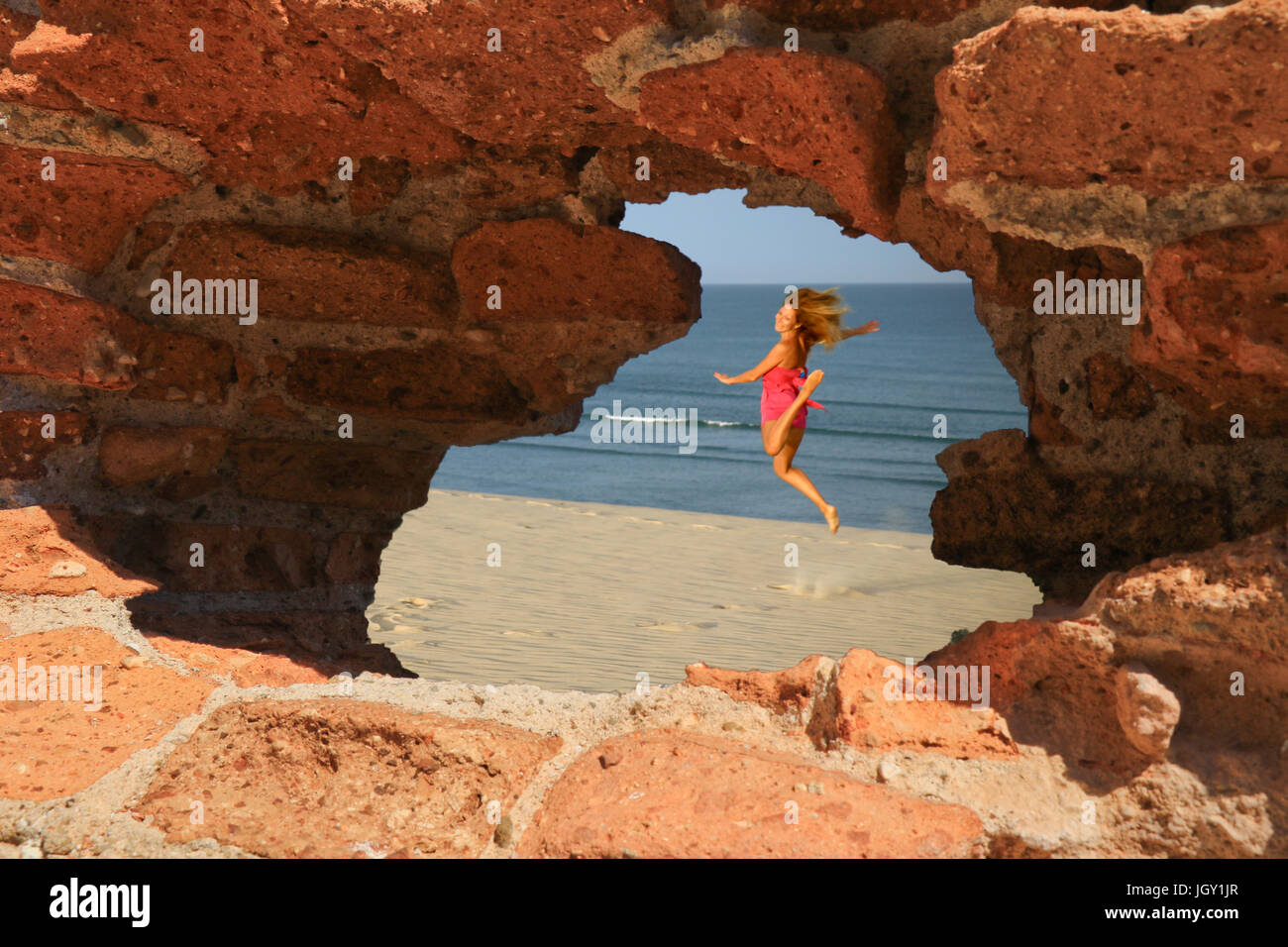 flying woman view through hole in rocks Stock Photo - Alamy