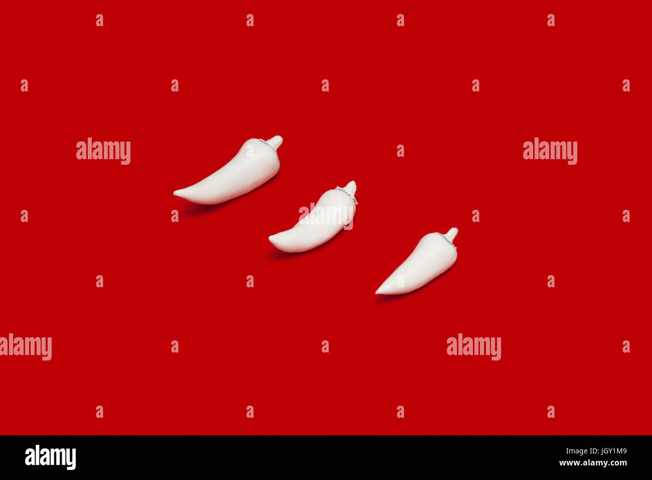 Chillies painted white on red background Stock Photo - Alamy