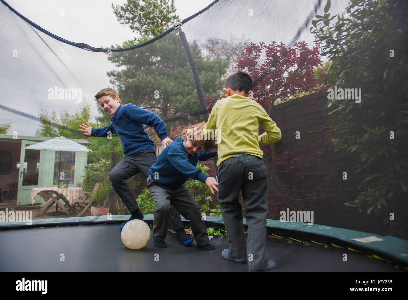 Boys on trampoline playing football Stock Photo - Alamy