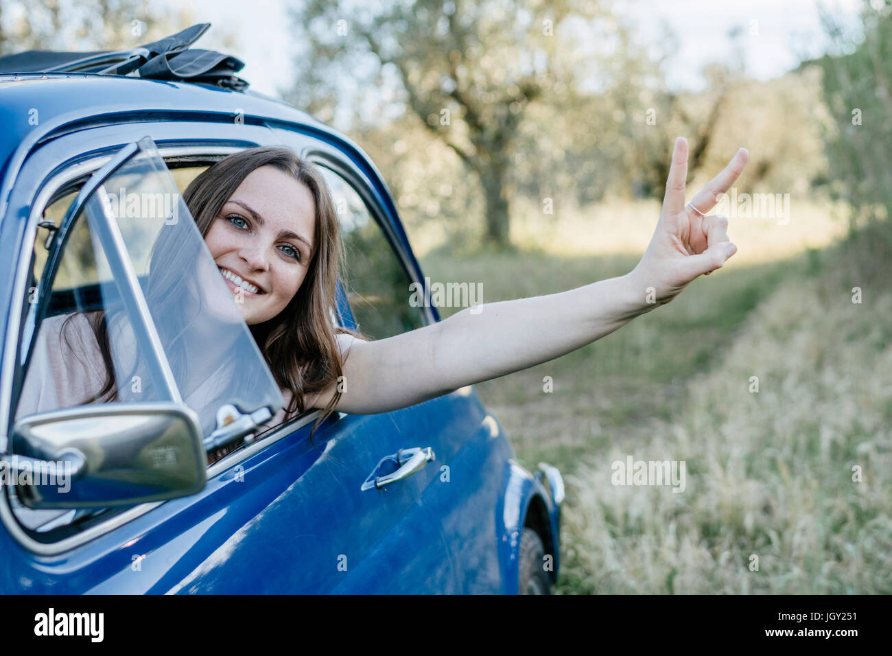 Woman looking out of car window smiling, peace sign, Firenze, Toscana ...