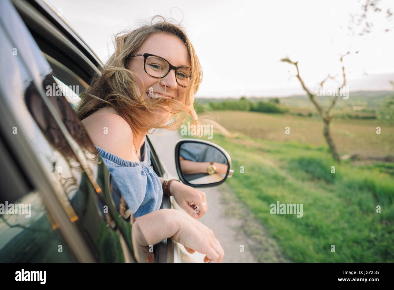 Young woman looking out of moving car window smiling, Firenze, Toscana ...