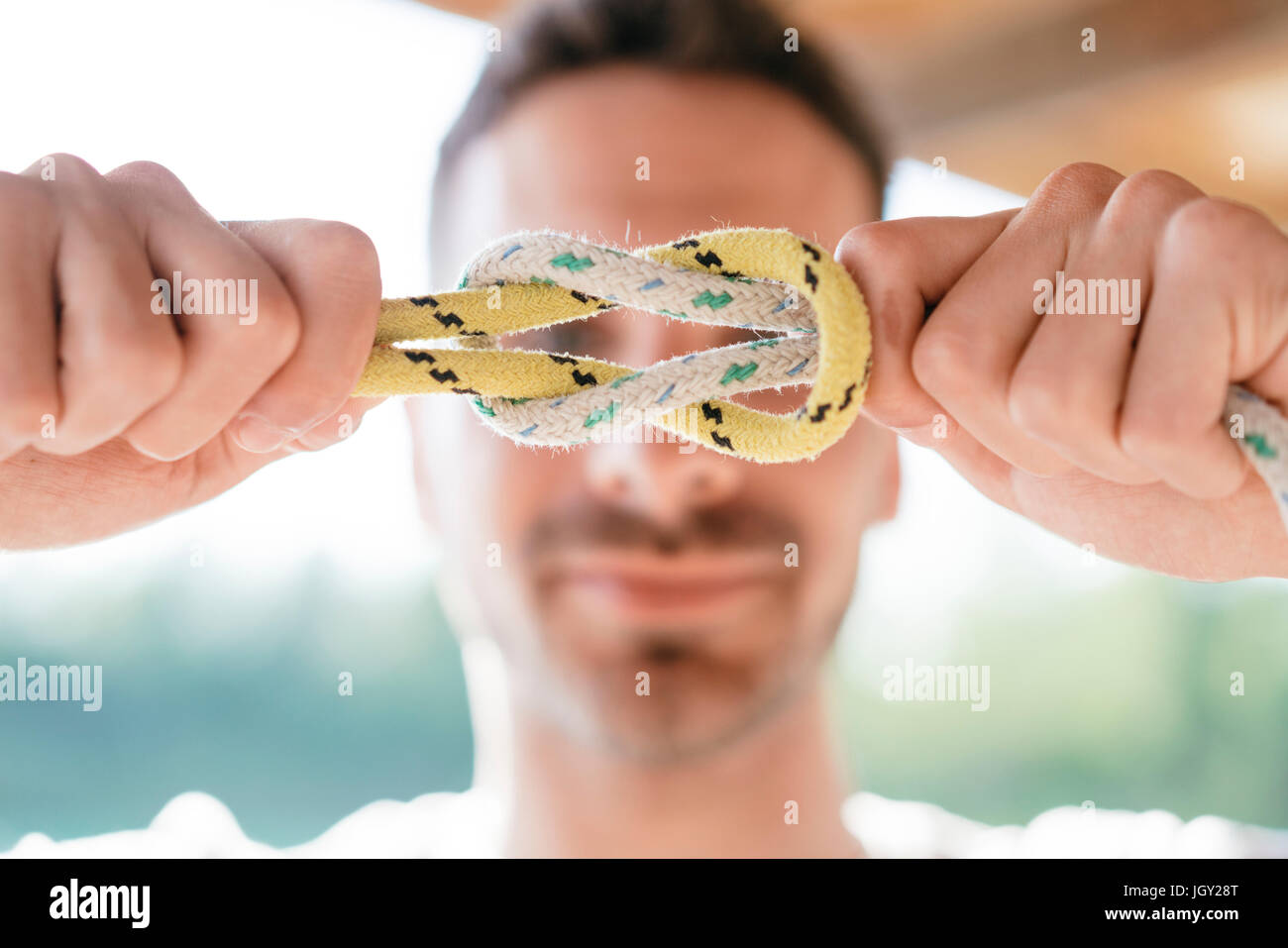 Man holding rope in front of face, showing nautical knot Stock Photo ...
