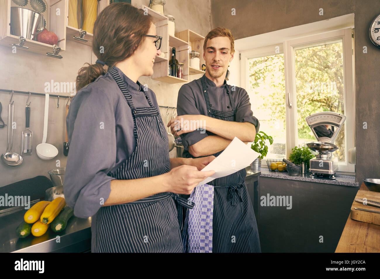 Chefs in kitchen chatting Stock Photo - Alamy