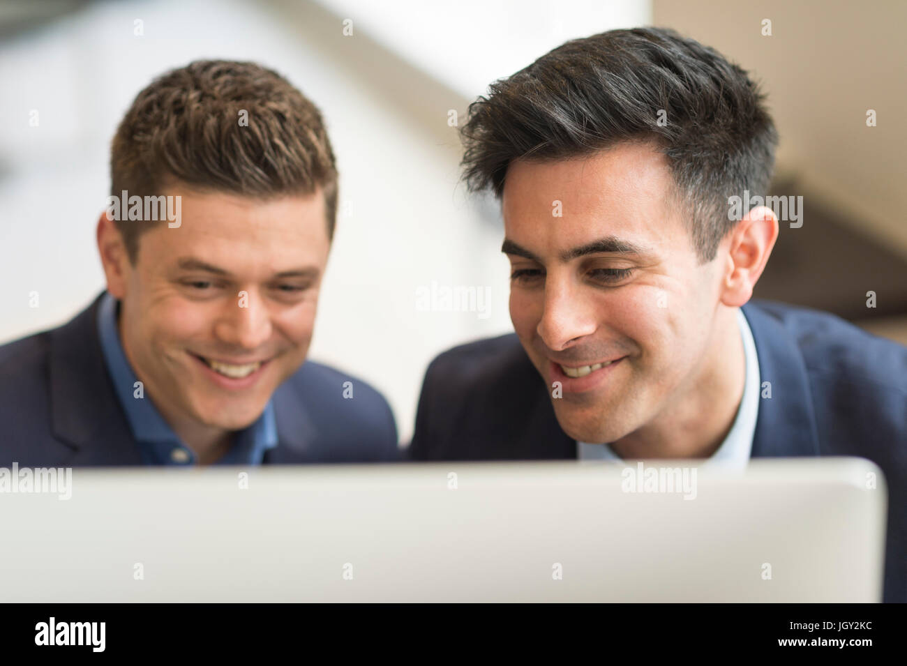 Two businessmen looking at computer in office Stock Photo - Alamy