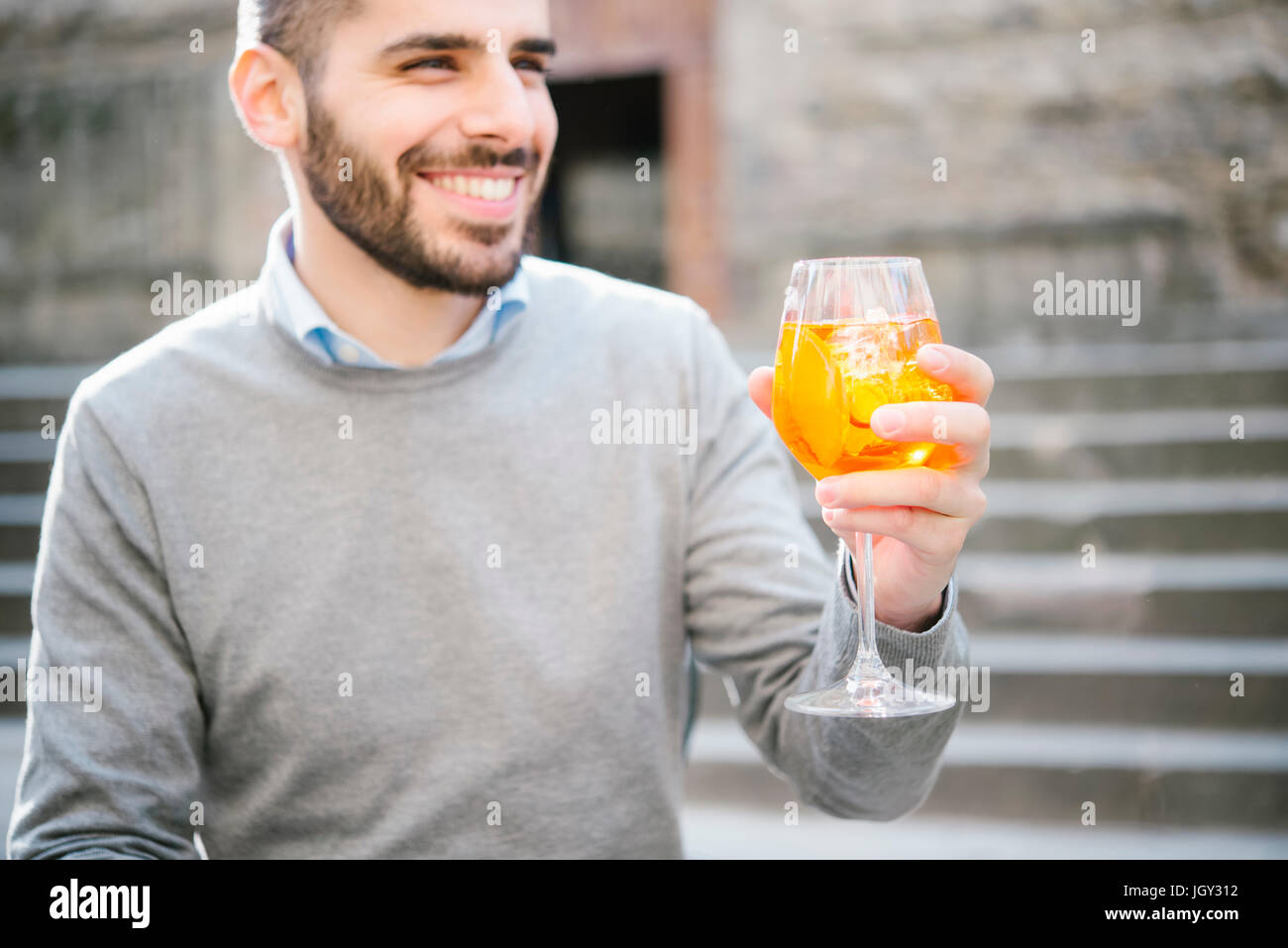 Portrait of young man, outdoors, raising glass Stock Photo - Alamy