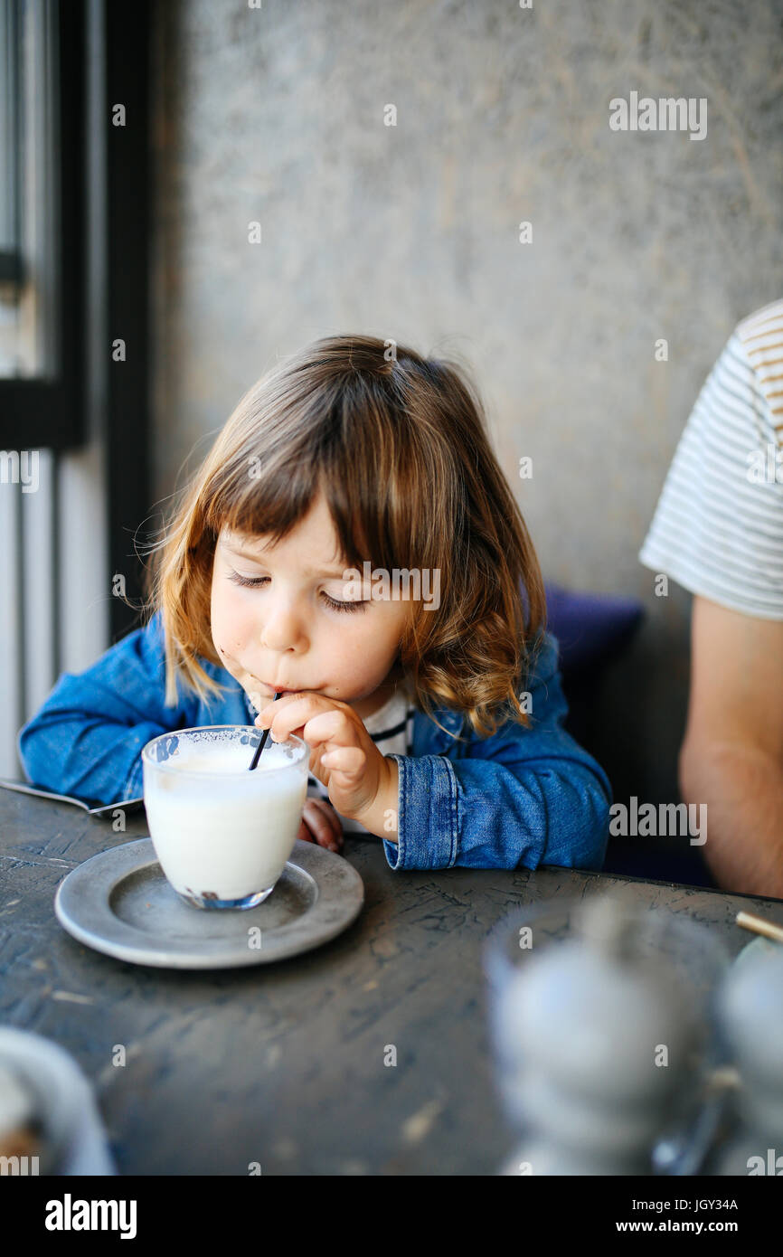 Girl sipping milk in cafe Stock Photo - Alamy