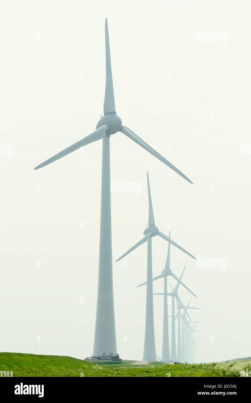 Row of wind turbines in field dyke landscape Stock Photo - Alamy