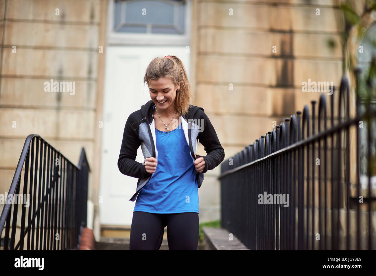 Young female runner moving front door down stairway Stock Photo - Alamy