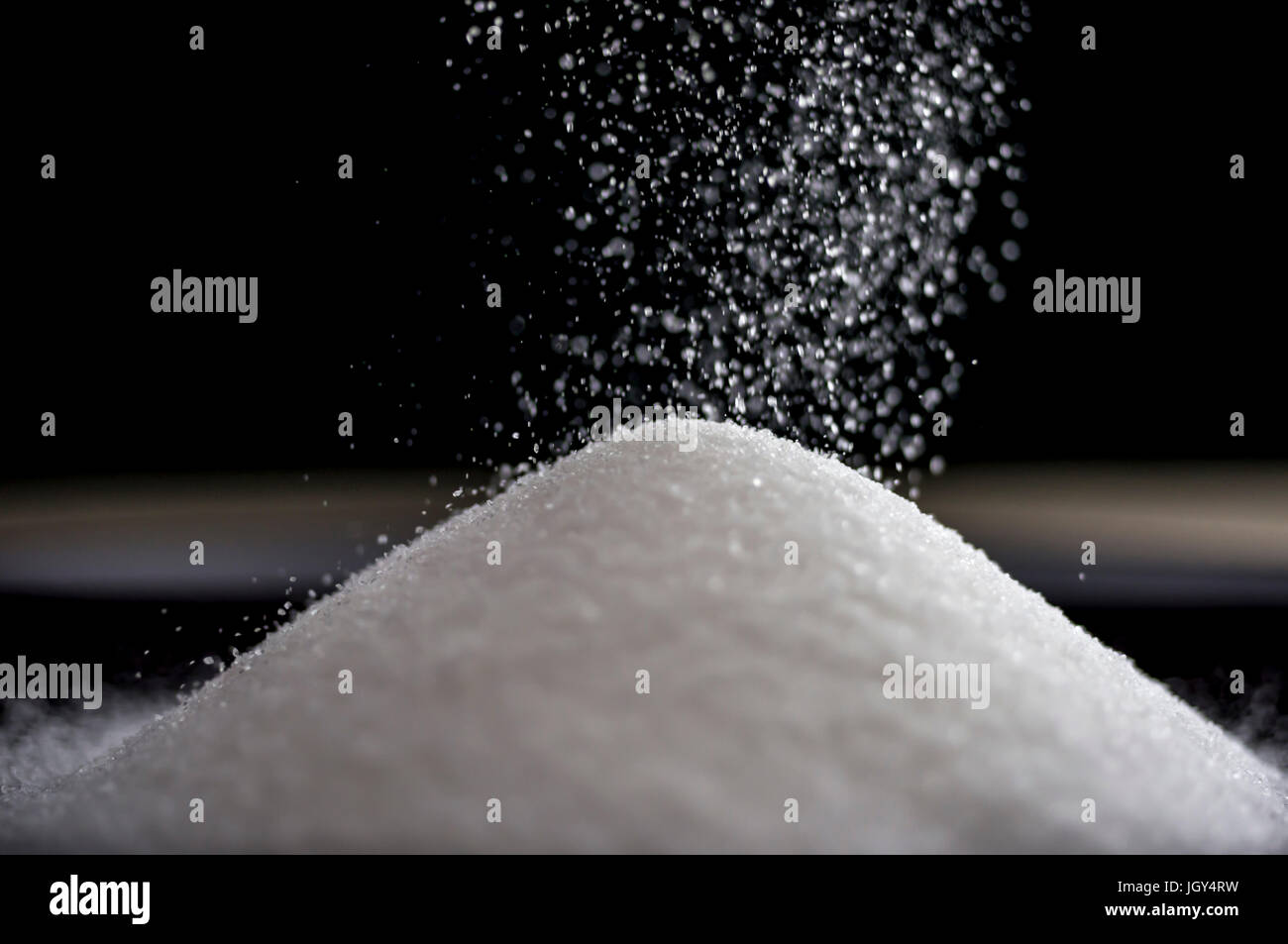 Close up shot of flowing sugar forming a pile as it falls Stock Photo ...