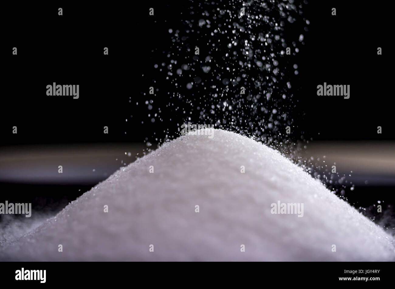 Close up shot of flowing sugar forming a pile as it falls Stock Photo ...