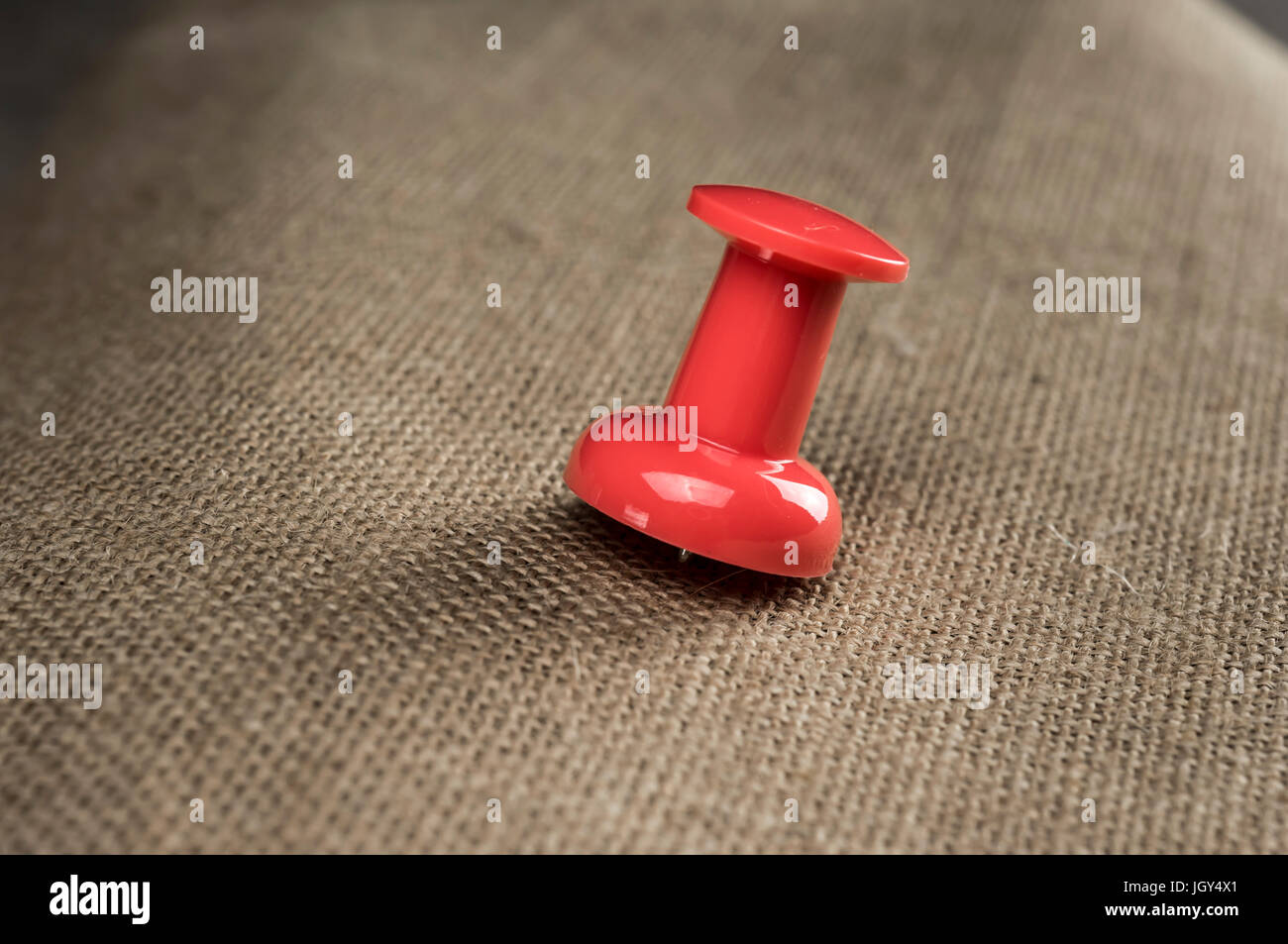 Macro shot of an orange push pin on hessian cloth Stock Photo - Alamy