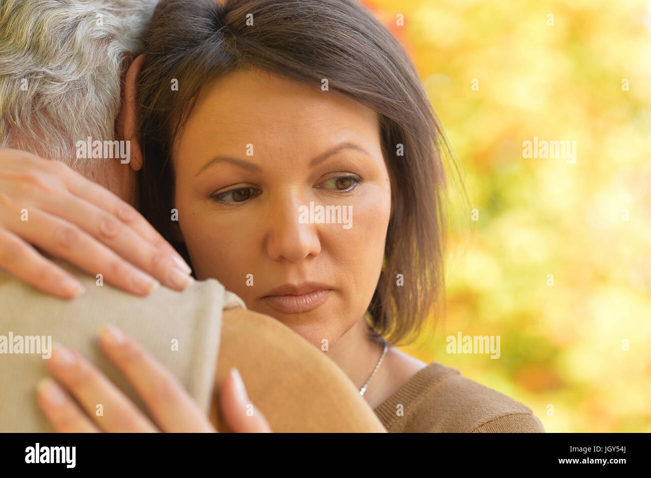 Sad woman and senior man hugging Stock Photo - Alamy