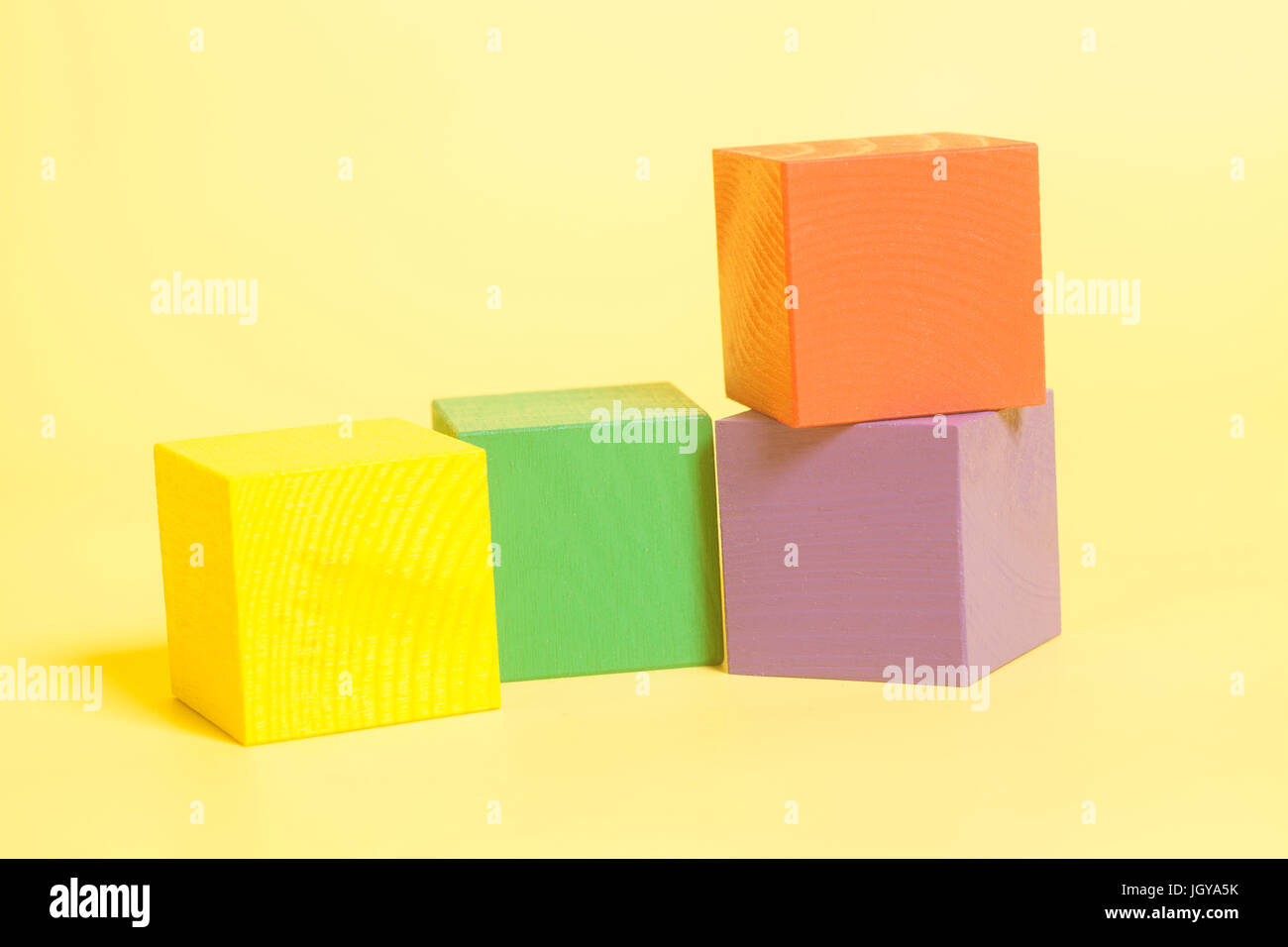 Multiple colored cubes on yellow background Stock Photo - Alamy