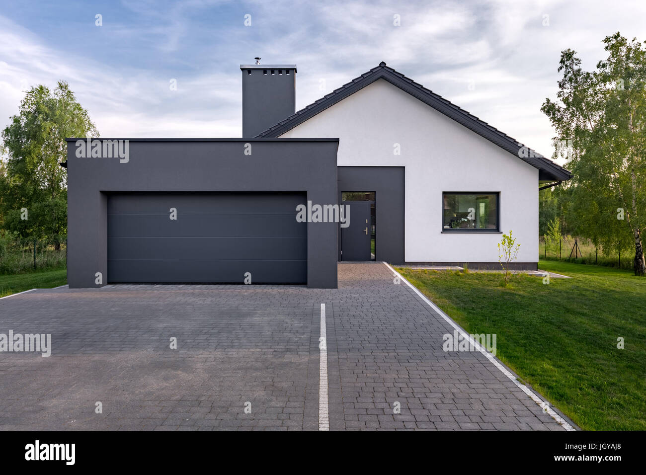 Cozy and modern house with garage and cobblestone driveway Stock Photo ...