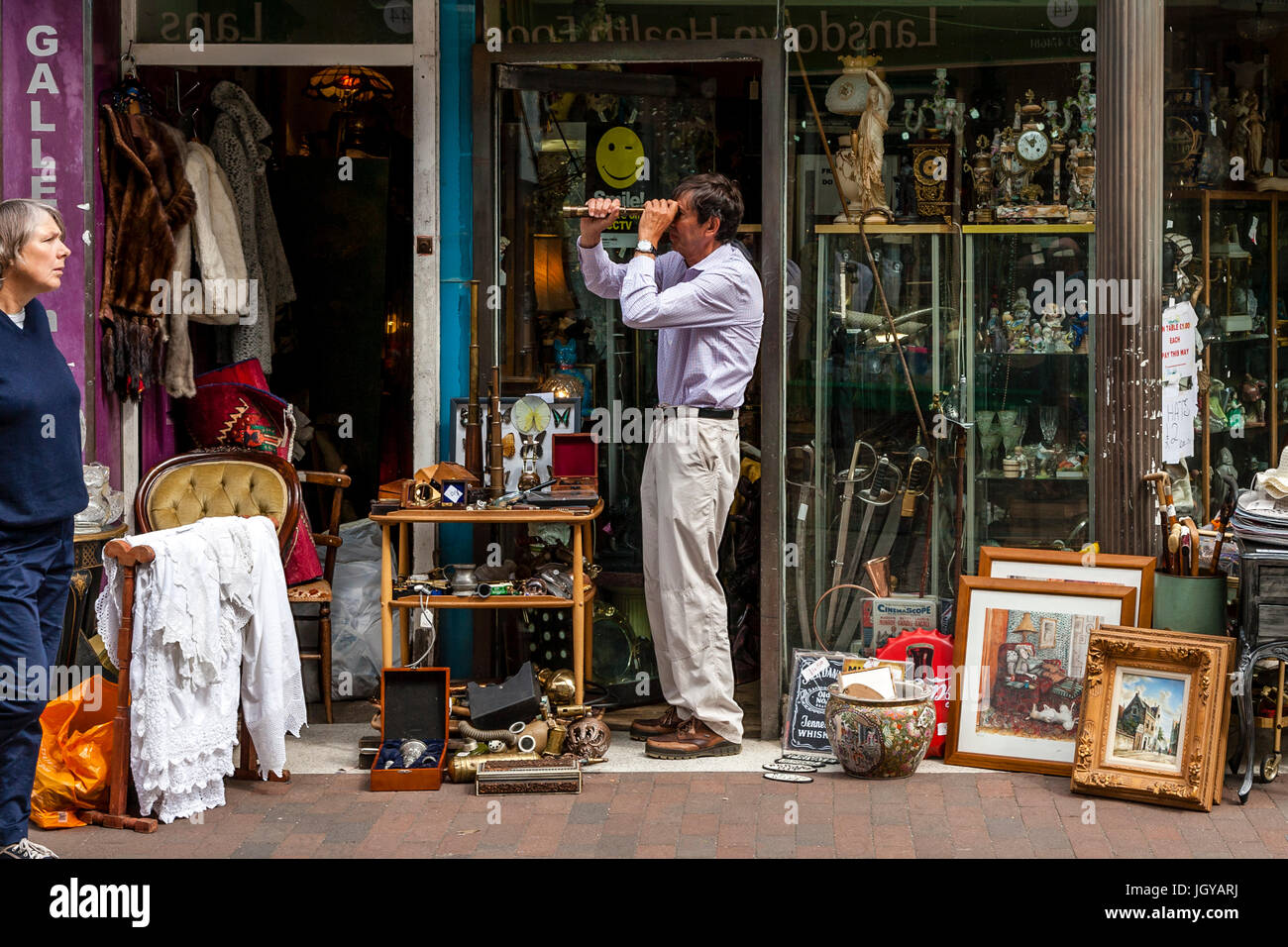 A Man Looks Through A Telescope Outside An Antiques Shop, High Street ...