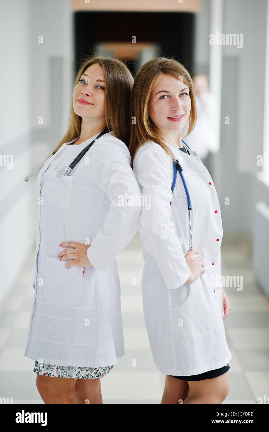 Two beautiful female doctors or medical workers in white coats posing ...