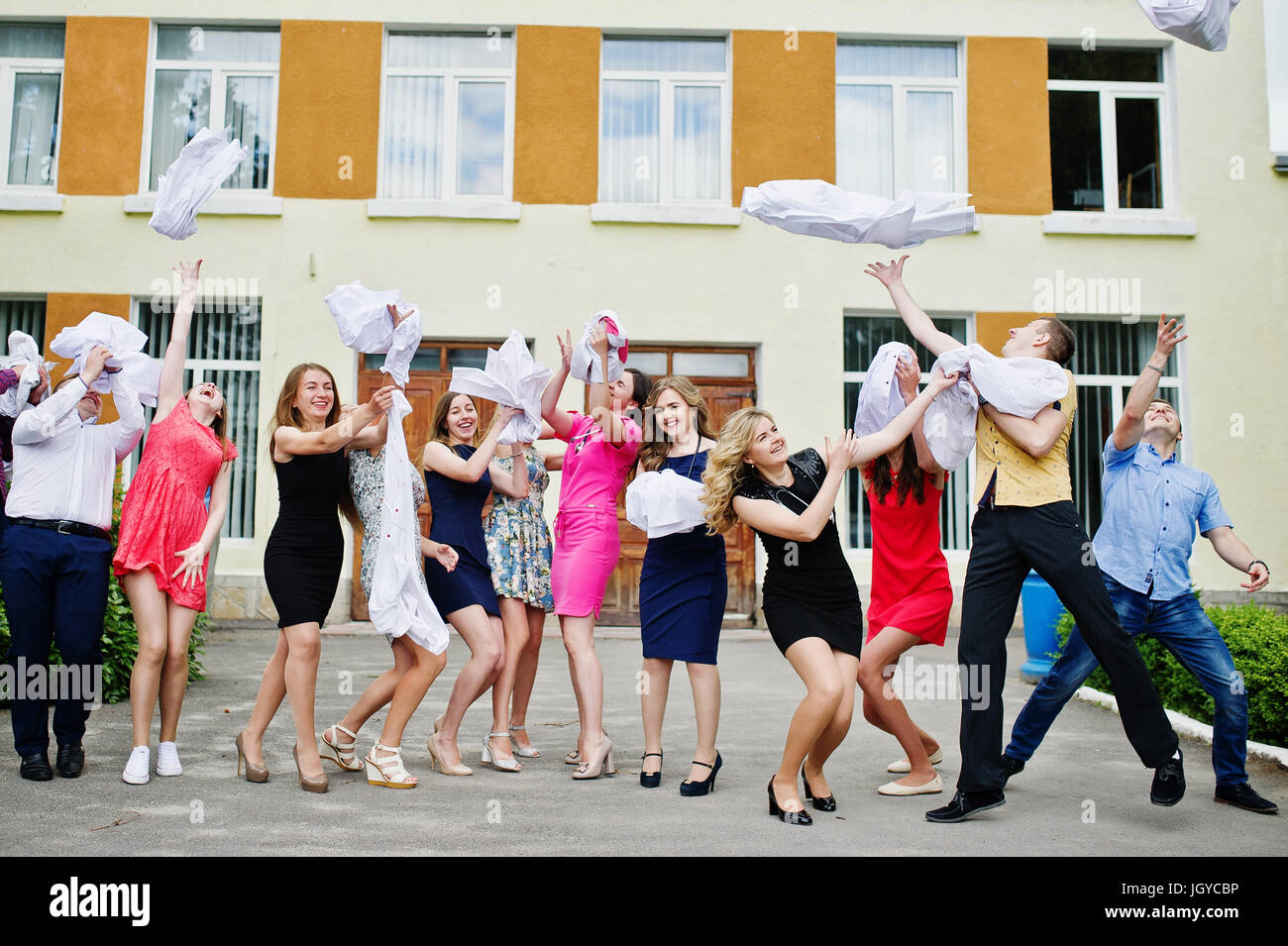 Crazy young doctors throwing their white coats up outside the hospital ...