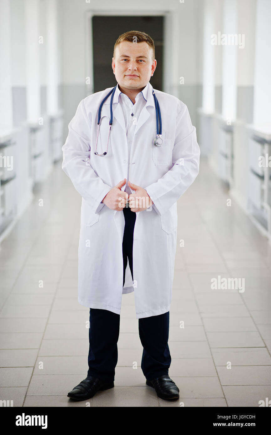 Handsome and confident young doctor in white coat with stethoscope ...