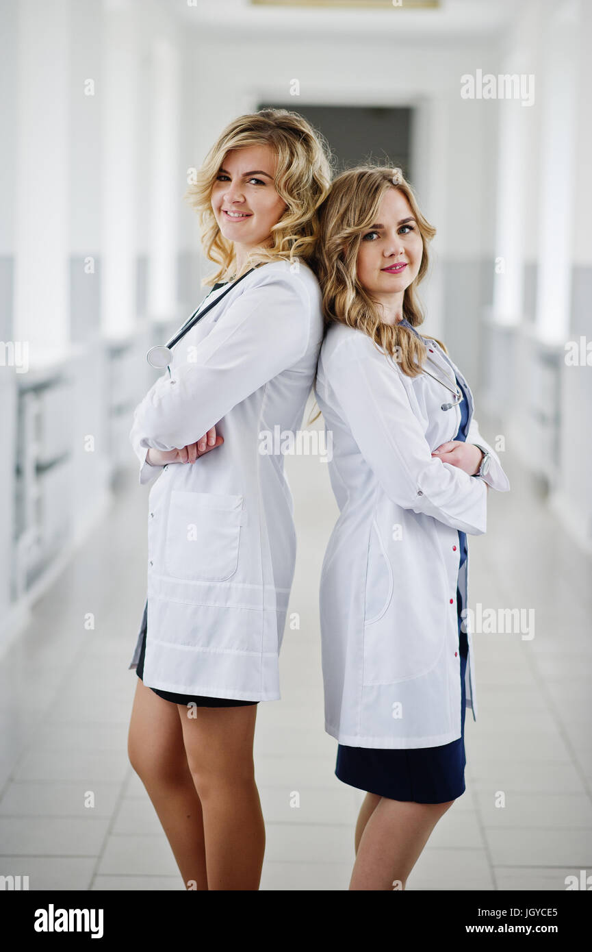 Two beautiful female doctors or medical workers in white coats posing ...