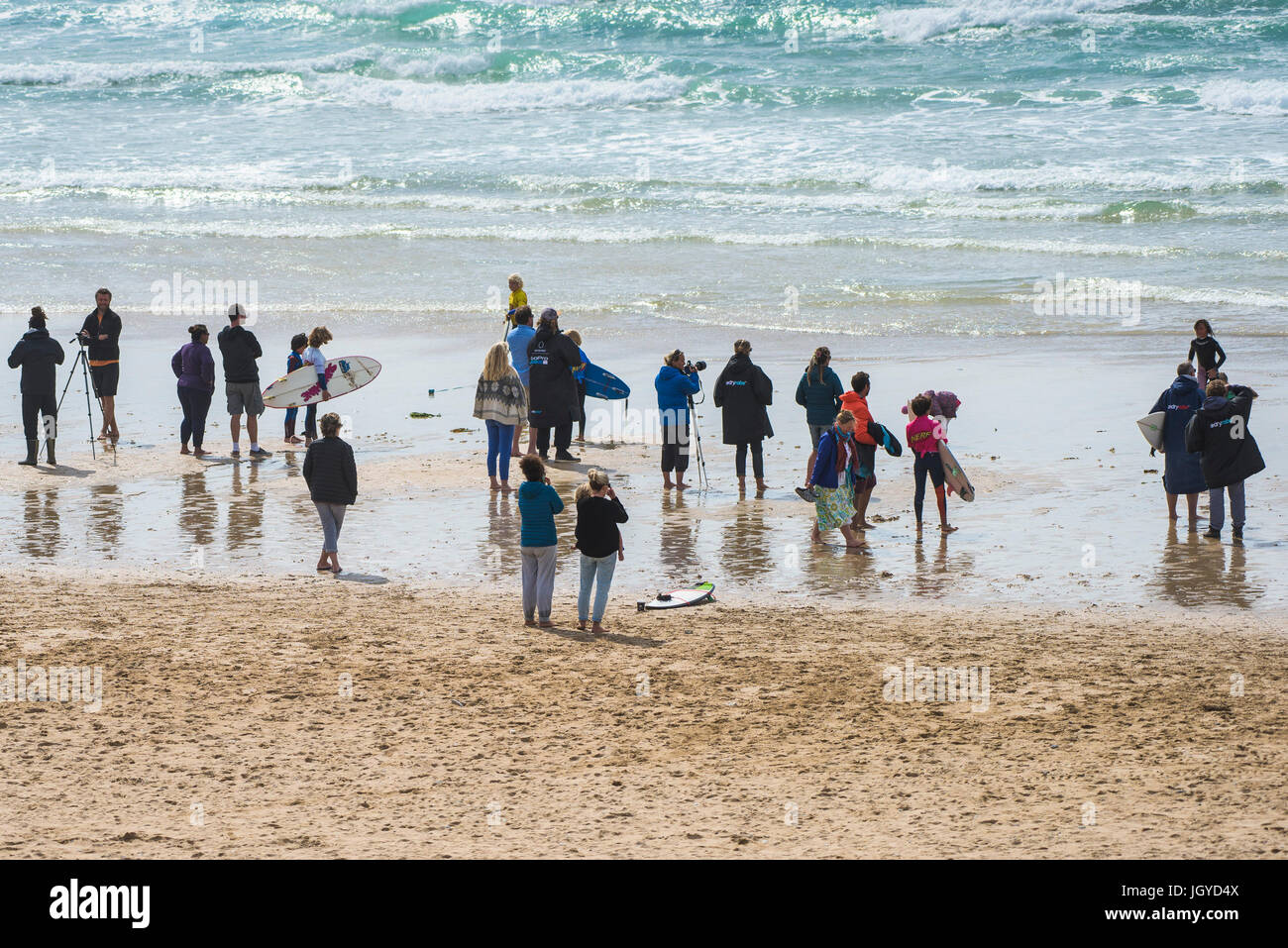People on a beach; People standing on the shoreline at Fistral beach in ...
