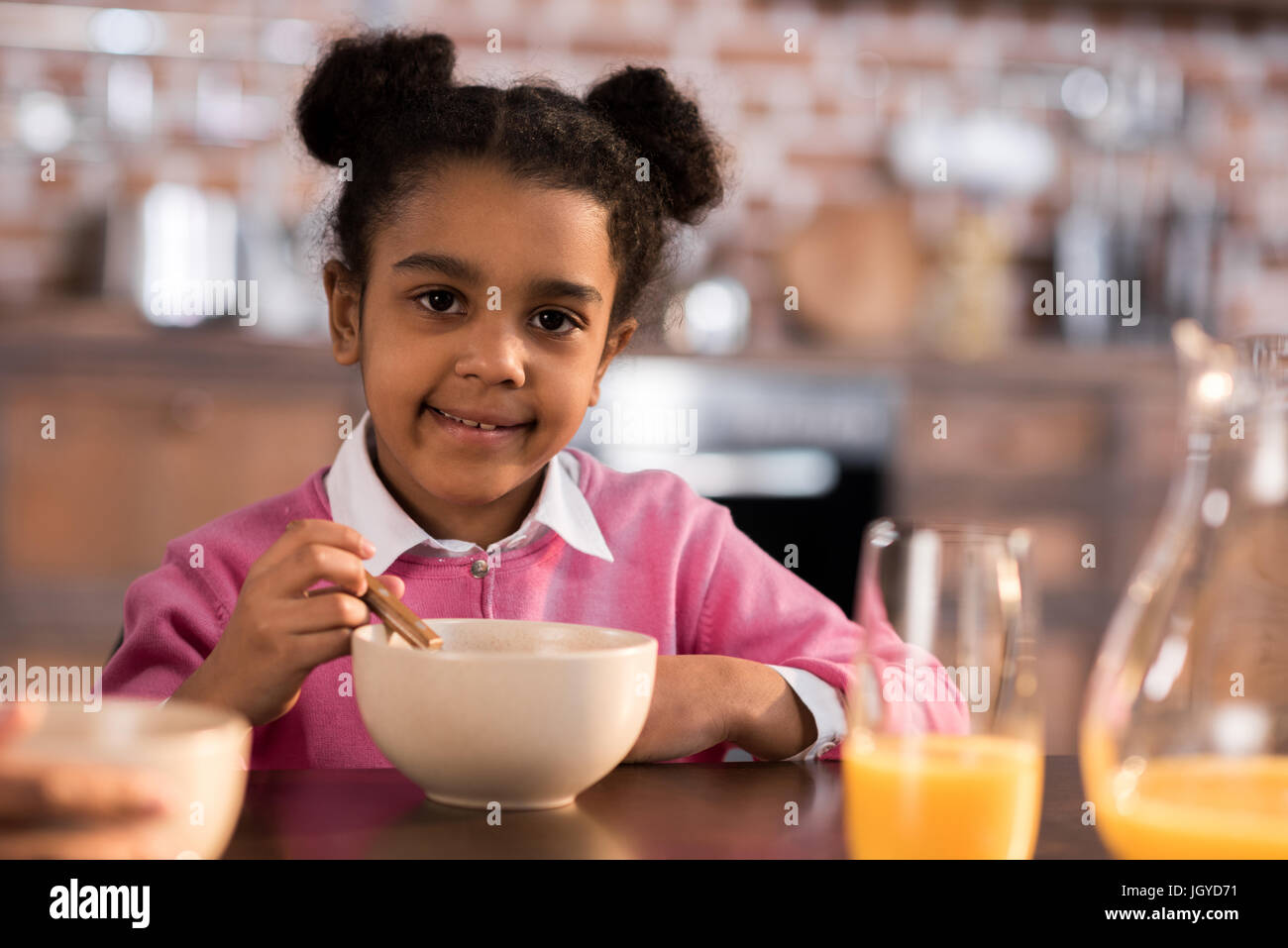 portrait of smiling little girl having breakfast at home Stock Photo ...