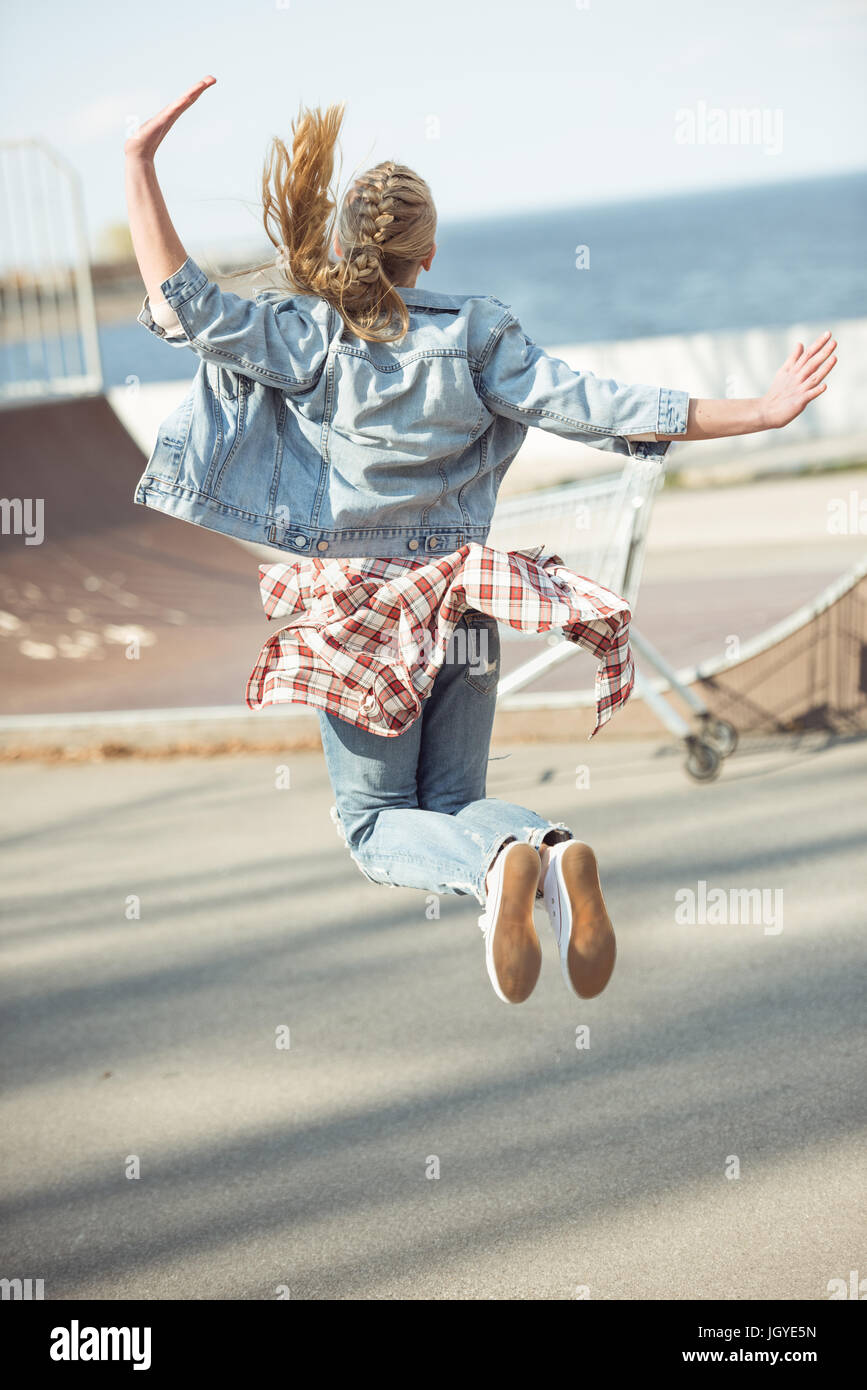 stylish teenage girl jumping at skateboard park, hipster style concept ...