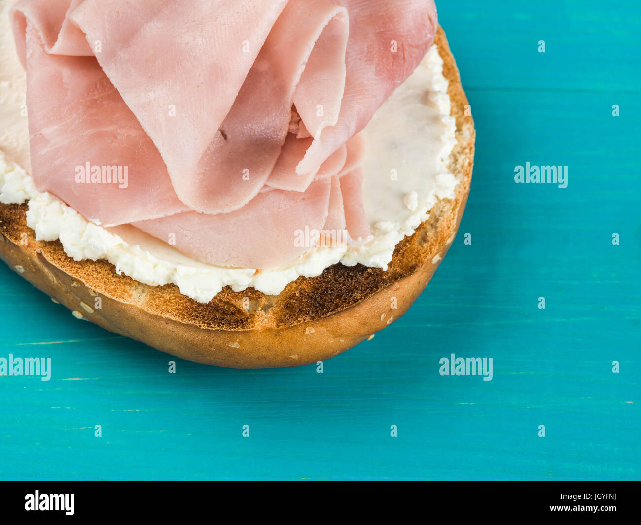 Ham and Soft Cheese Spread Sesame Bagel Against A Blue Background Stock ...
