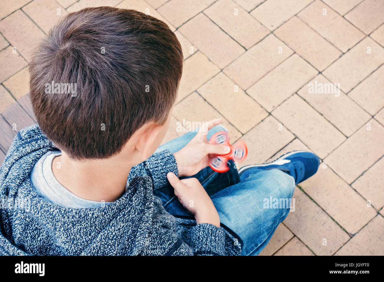 Boy playing with spinner outdoor Stock Photo - Alamy