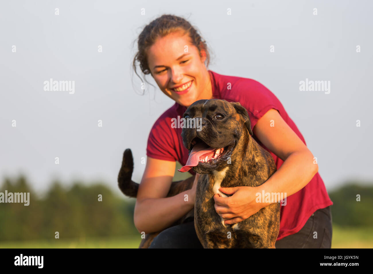 picture of a young girl who is hugging her boxer dog Stock Photo - Alamy
